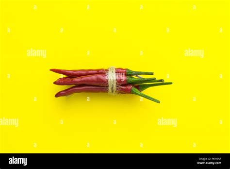 Top View Red Chili Pepper Tied With Braid On A Yellow Background