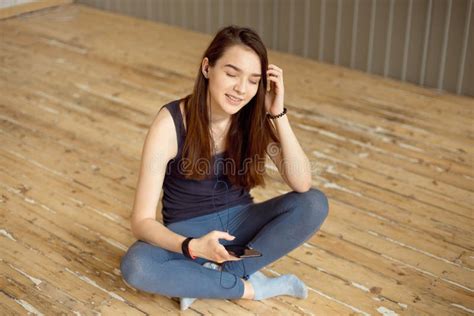 Athletic Girl In Sportswear Sitting On The Floor And Relaxing After A