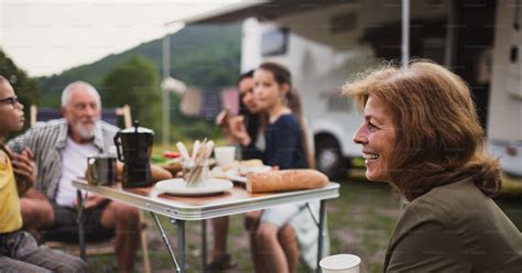 다세대 가족이 야외에서 자동차로 앉아 식사를 하는 캐러밴 휴가 여행 사진 Unsplash의 휴식 이미지
