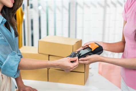 젊은 여성의 손을 닫아 꽃병 상품 주문에 신용 카드 지불을 사용합니다 창고 매장에서 중소기업의 제품을 구매하기 위해 쉽고 빠른 비접촉 결제를 하는 매력적인 여성 고객 사진