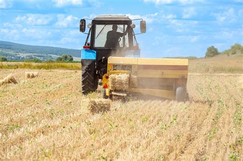 Premium Photo Tractor Pulling Baler To Make Fresh Hay Bales