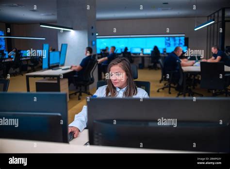 Close Up Photo Of A Security Female Agent Monitoring The CCTV In A Main Data Center Office Stock