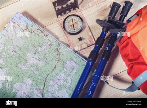 Compass Map Trekking Poles And Backpack On A Wooden Background Stock