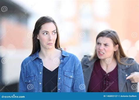 Angry Woman Scolding Her Confused Friend In The Street Stock Image
