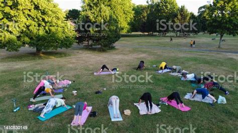 더운 여름의 일몰에 공공 공원에서 함께 요가를 운동하는 여성 그룹 Wardown Park Luton England Uk의 공중