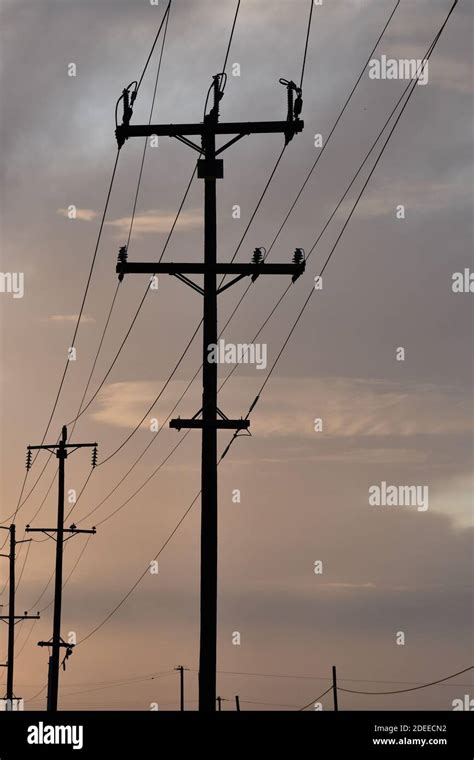 A Rainy Cloudscape Over Wooden Utility Pole Silhouettes With Messy