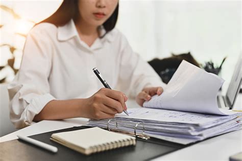 집중된 여성 회계 분석가는 부기 문서를 작업하고 사무실 책상에서 계약서에 서명합니다 20 24세에 대한 스톡 사진 및 기타 이미지 20 24세 25 29세 30 34