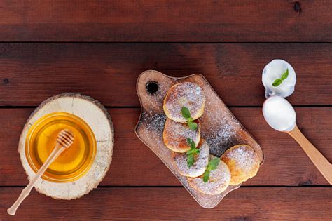 코 티 지 치즈 뿌려 가루 설탕과 신선한 민트 팬케이크 나무 보드에 치즈입니다 나무로 되는 숟가락에 사 우 어 크림입니다 자연 백그라운드에 꿀 낙농 장 제품입니다 공간 복사