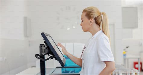 아름다운 금발 실험실 조수가 실험실에 서서 컴퓨터를 사용하여 테스트 결과를 입력합니다 사진 Unsplash의 세르비아 이미지