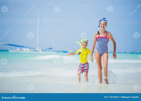 Brother And Sister Playing On The Beach During The Hot Summer Vacation