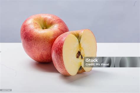 깨끗한 흰색 표면과 밝은 배경에 씨앗이 있는 전체 빨간 사과와 반 컷 사과는 육즙이 많은 질감 신선한 과육 및 잘 익은 건강한