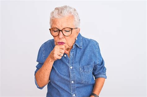 데님 셔츠와 안경을 착용한 선임 회색 머리 여성은 감기 나 기관지염의 증상으로 기분이 나고 기침을 합니다 헬스케어 개념 감기와 독감에 대한 스톡 사진 및 기타 이미지