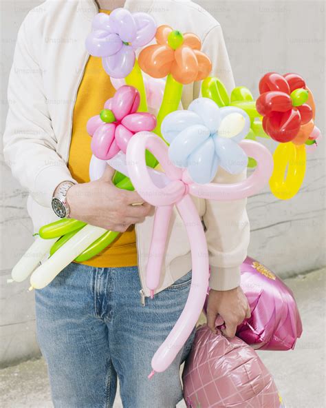 한 사람이 형형색색의 풍선 꽃다발을 들고 있습니다 사진 Unsplash의 꽃 이미지