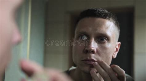 Man With Cucumbers On His Face Close Up Reflection In The Mirror