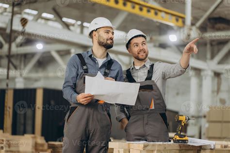 Engineers Discussing Blueprint In Modular Building Factory 53512467