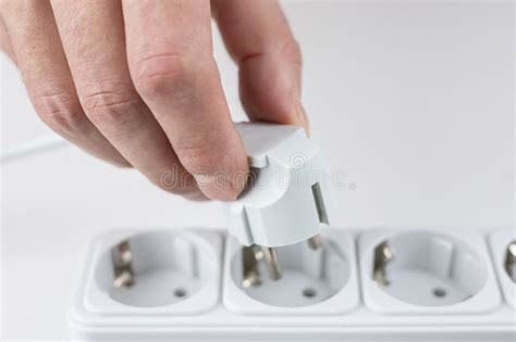 Close Up Of Woman S Hand Inserting Electric Plug Into Socket