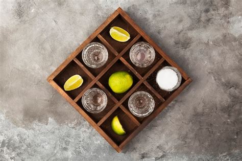 Premium Photo Tequila Shots Limes And Salt On Wooden Board