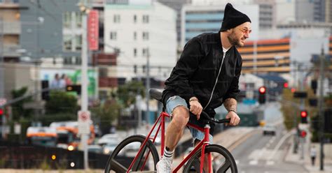 빨간 자전거를 타고 거리를 내려가는 남자 사진 Unsplash의 도시 이미지