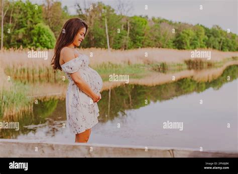 Portrait of pregnant woman holding big belly baby bump happy and ...