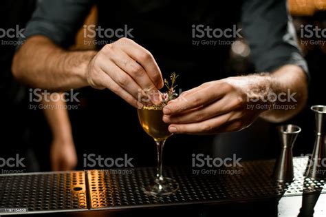 전문 남성 바텐더는 꽃과 나뭇 가지와 노란색 투명 알코올 칵테일 음료를 장식 각얼음에 대한 스톡 사진 및 기타 이미지 각얼음