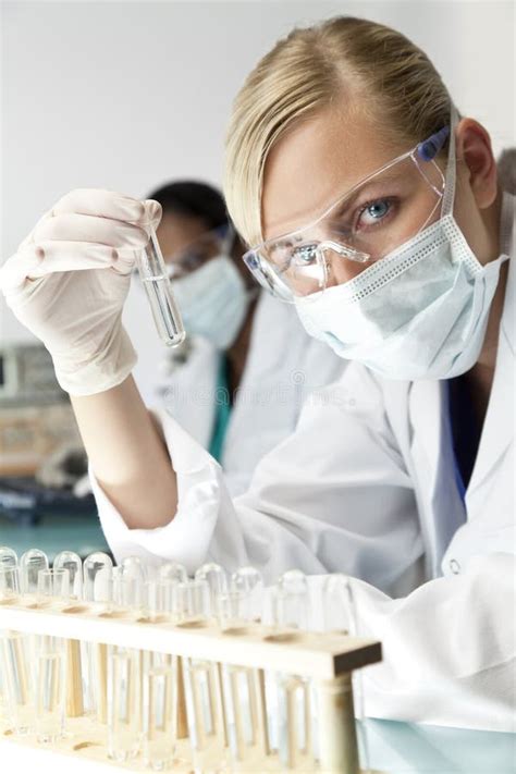 Científicos De Sexo Femenino Que Usan Los Microscopios En Laboratorio