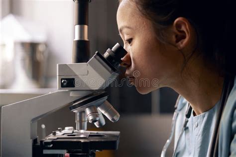 Asian Lab Assistant Uses Microscope Working With Material Sample At