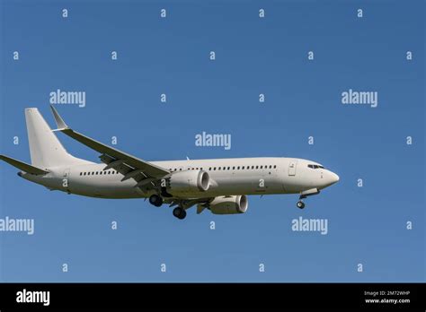 White Passenger Plane Against Blue Sky Just Before Landing At Airport