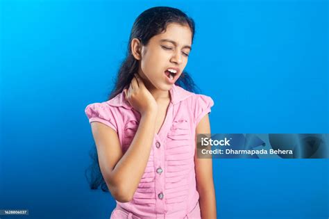 Isolated On Blue Background Indian Girl Massaging Her Neck Having Neck