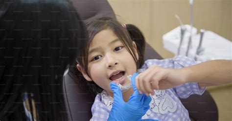 치과 진료소 치아 검진 및 건강한 치아 개념에서 어린 소녀에게 Invisalign 보여주는 여성 치과 의사 사진