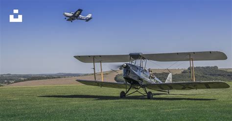 무성한 녹색 들판 위를 날아가는 작은 비행기 사진 Unsplash의 무료 복 엽 비행기 이미지