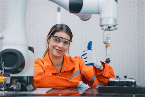 Engineering Student Assembling A Robotic Arm Using A Computer In A Technology Workshop Service