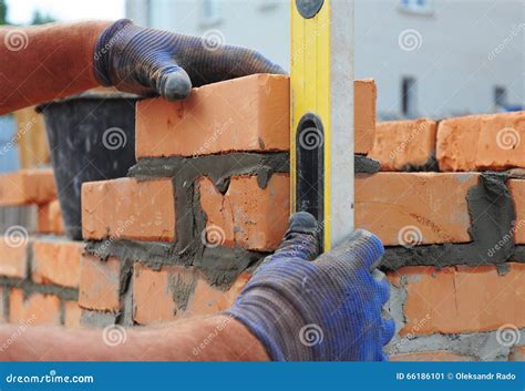 Bricklayer Using Trowel And Hands For Building Exterior Brick Walls