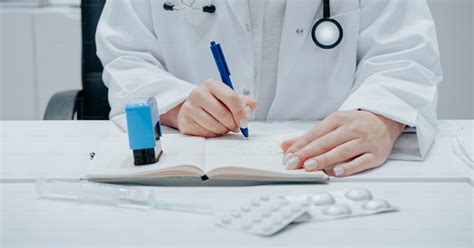 흰 코트를 입은 사람이 책에 글을 쓰고 있다 사진 Unsplash의 약물 치료 이미지