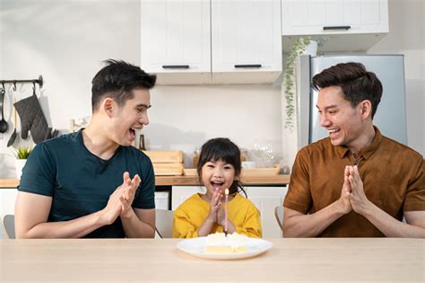 아시아 매력적인 Lgbtq 게이 가족은 집에서 생일 소녀 아이를 축하합니다 잘 생긴 남성 부부는 집에서 그녀의 특별한 날에