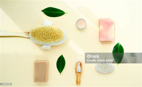 마사지 브러쉬 단단한 비누 목욕 소금 파스텔 베이지 색 배경의 녹색 잎이 있는 Spa 유기농 천연 화장품 제로 폐기물 플라스틱