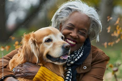 Mature Candid Black Woman Cuddling Golden Retriever Dog Outdoors In