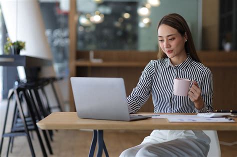 행복한 사무실에서 노트북으로 일하고 아침에 커피를 마시는 매력적인 젊은 아름다운 비즈니스 여성 30 34세에 대한 스톡 사진 및