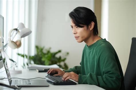 Premium Photo Pensive Young Software Developer Looking At Laptop
