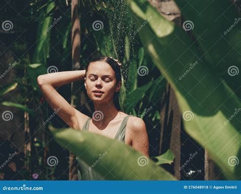 A Woman A Body In A Swimsuit Washes Her Head In A Tropical Shower
