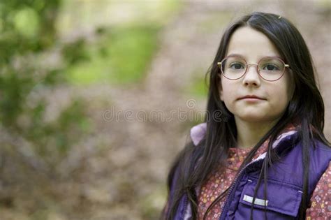A Small Beautiful Smiling Long Haired Dark Haired Girl In Glasses And A
