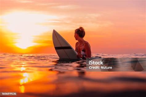 따뜻한 일몰이나 일출에 바다에서 서핑보드를 탄 서퍼 소녀 서핑 수상 스포츠에 대한 스톡 사진 및 기타 이미지 서핑 수상 스포츠 캘리포니아 일몰 Istock