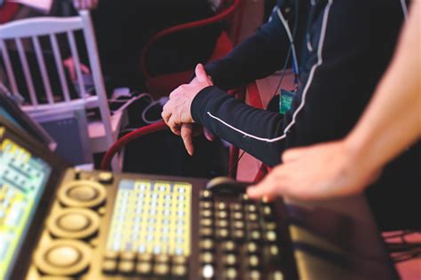 View Of Lighting Technician Operator Working On Mixing Console