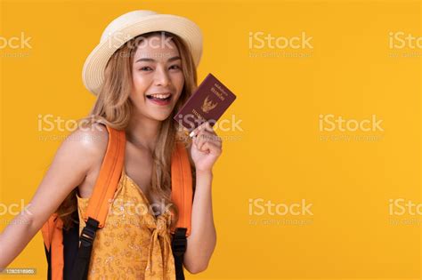 여행 가방과 여름 모자를 가진 쾌활한 배낭 여행자 관광 아시아 여성 여행 및 여권을 들고 준비 노란색 배경에 고립 여행 및 휴가