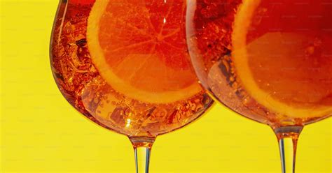 Spritz 노란색 배경에 반짝이는 프로세코 쓴맛 셀츠 오렌지 슬라이스를 곁들인 칵테일 사진 Unsplash의 마시다 이미지