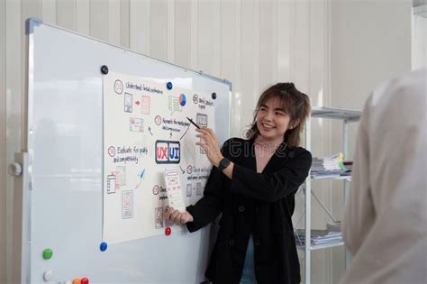 Asian Ux Developer And Ui Designer Presenting Mobile App Interface