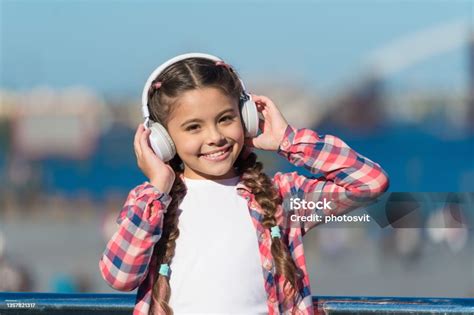 사랑스러운 음악 애호가 어린 아이는 음악을 듣는 것을 즐깁니다 스테레오 헤드폰을 착용한 어린 소녀 무선 헤드셋을 갖춘 어린 아이 레저 또는 음악 교육을 위한 기술을 사용하는