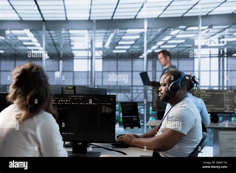 African American Man In Data Center Coordinating Deployment Of Server