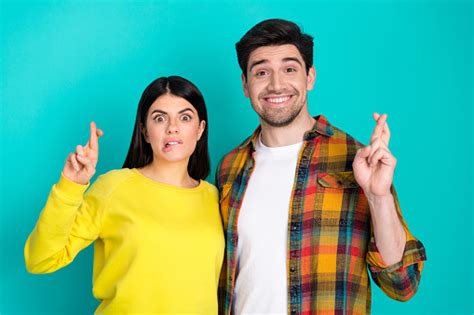 청록색 배경막을 배경으로 희망과 흥분을 표현하며 손가락을 교차하는 즐거운 젊은 커플 사랑과 연결을 보여주는 25 29세에 대한 스톡 사진 및 기타 이미지 Istock