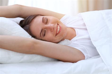 Beautiful Young And Happy Woman Stretching Hands While Lying In Bed