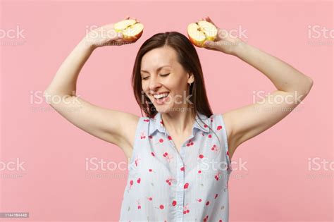 여름 옷에 웃는 젊은 여자 핑크 파스텔 배경에 고립 된 신선한 잘 익은 사과 과일의 Halfs 지주를 유지 사람들은 생생한